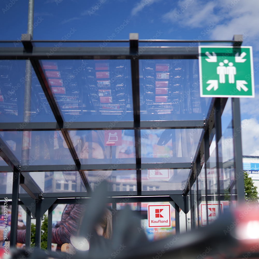 Kaufland company logo in a covered shopping cart hall. Push carts ...