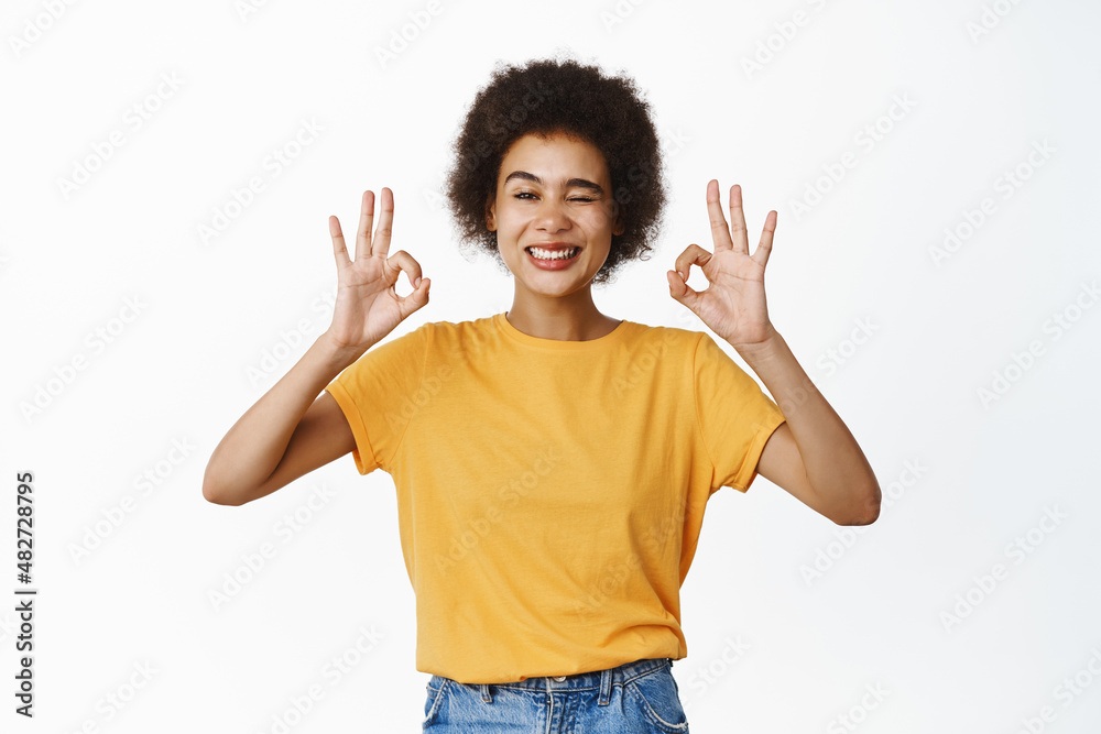 Image of smiling african woman winks and shows, zero, okay signs in ...