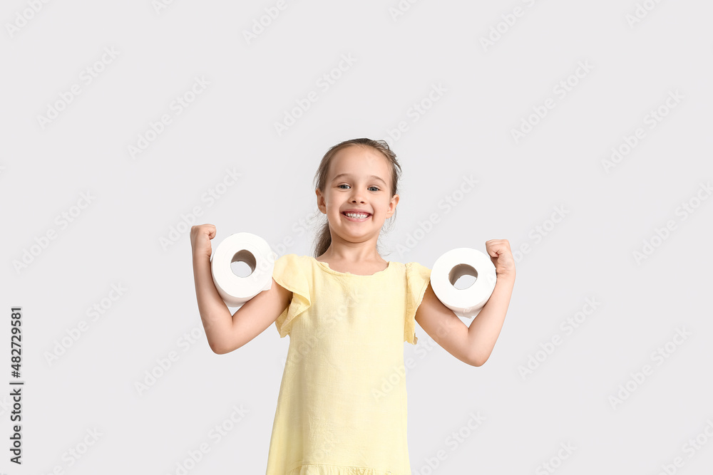 Funny little girl with rolls of toilet paper on light background Stock ...
