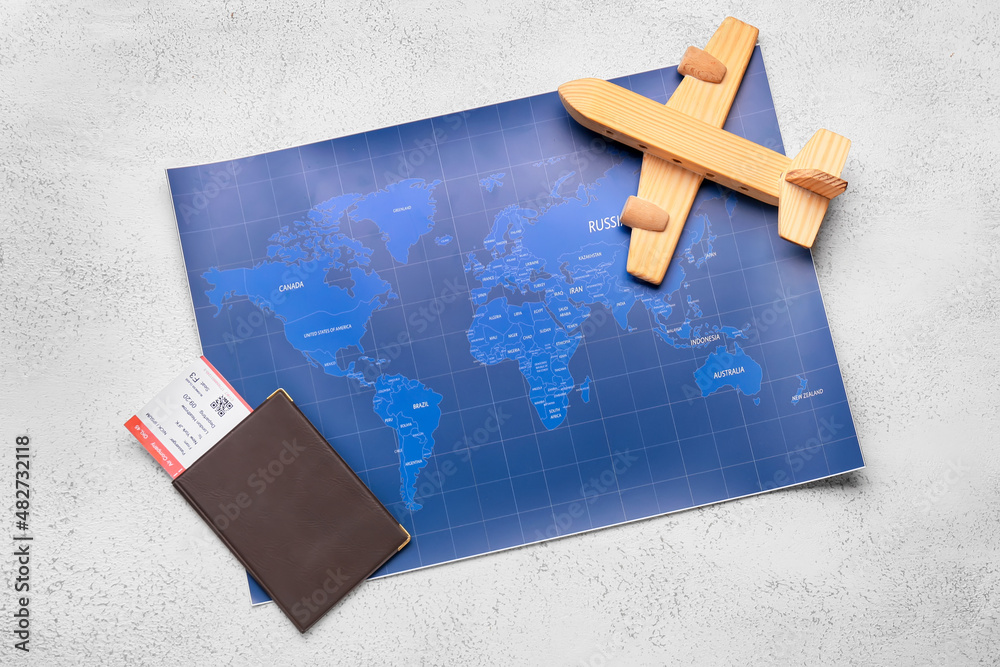 World map, passport with ticket and wooden plane on light background ...