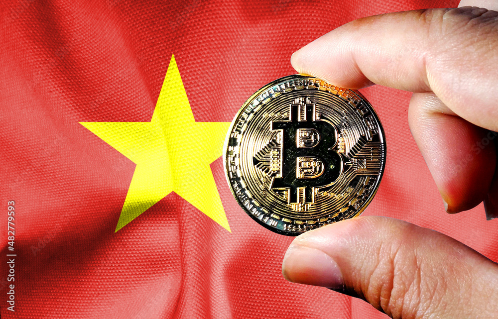 Hold a physical version of Bitcoin (the new virtual currency) and the flag of Vietnam. Vietnam ...