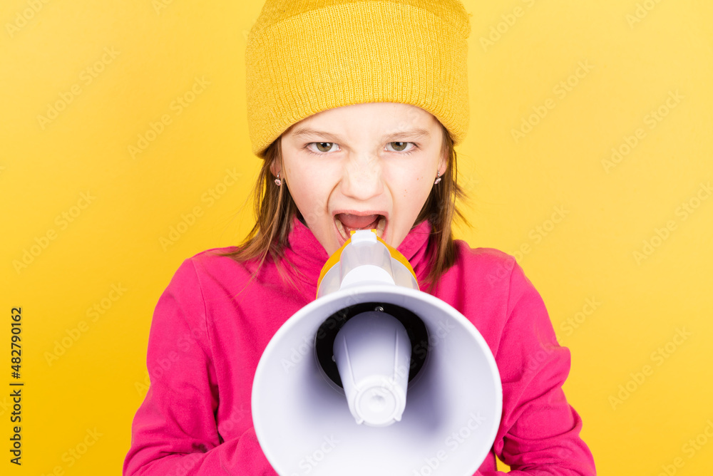 Angry child shouting on megaphone while looking to camera. Childhood ...