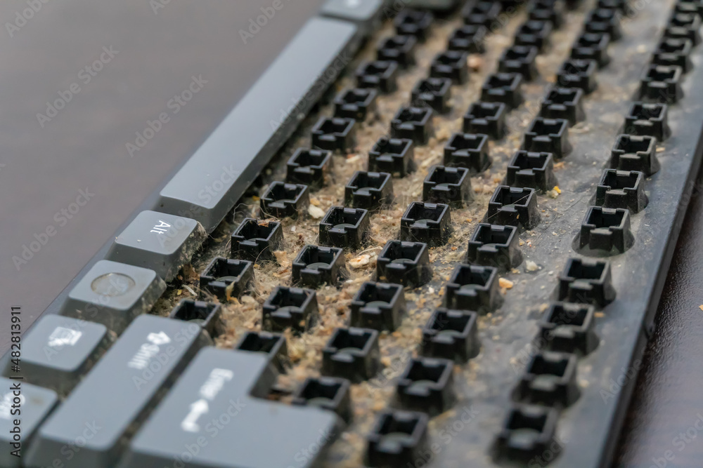 Close-up of a very dirty disassembled computer keyboard on the table ...