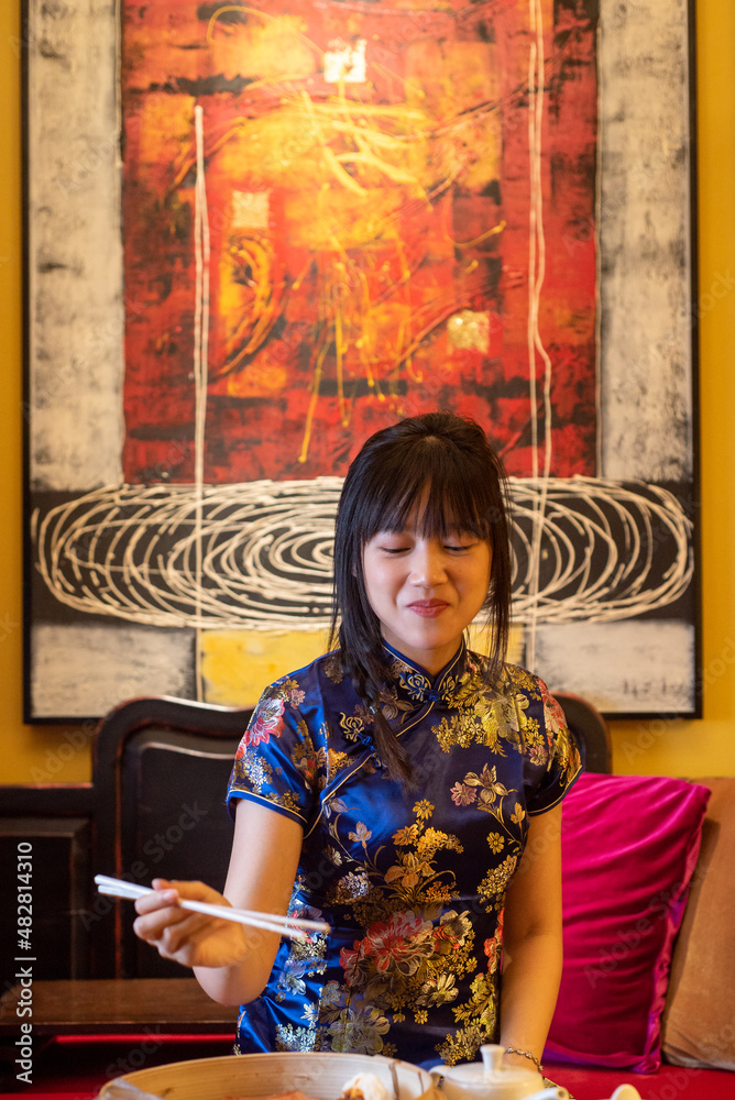 An Asian Girl is eating Dim Sum in a Chinese dress Stock Photo | Adobe ...