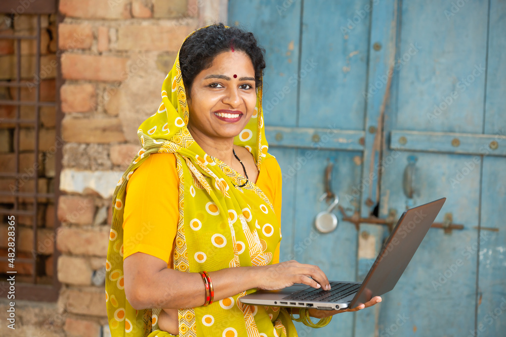 Portrait of Happy young rural indian woman using laptop. Smiling female ...