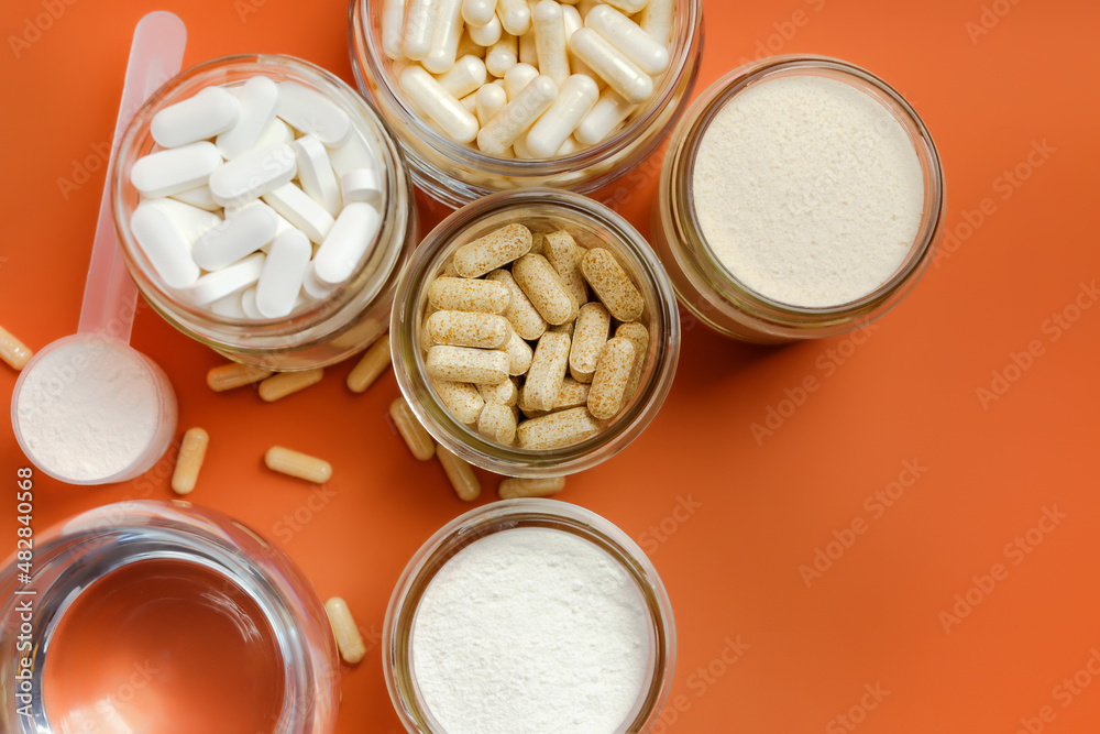 Nutrition supplements, glass of water and different vitamins such as ...