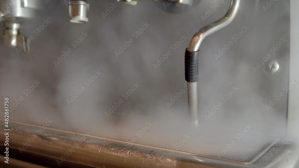 Hot water pouring from shower screen of group head of coffee machine ...