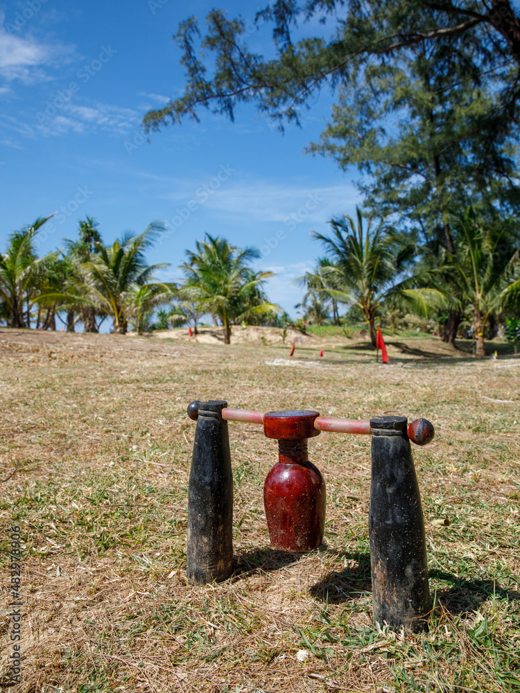 Close up red and brown woodball goal gate on the beach with blur palm ...