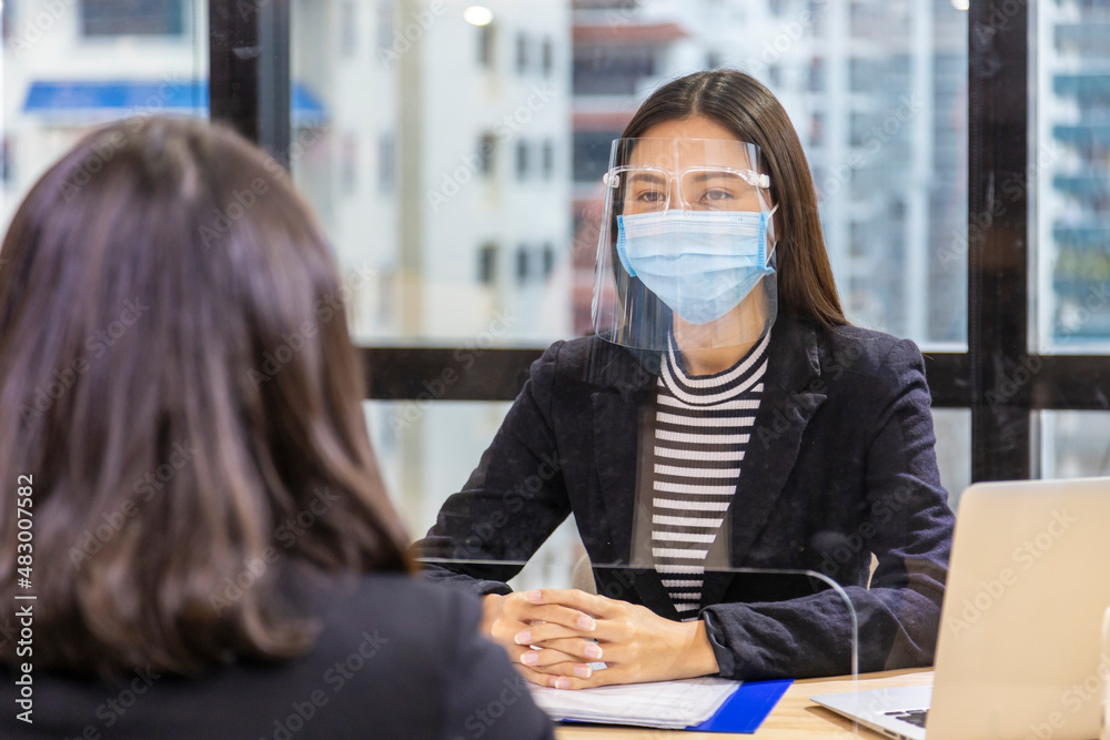 Manager from HR department wearing facial mask is interviewing new ...