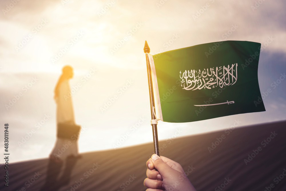Man hand waving Saudi Arabia flag in the desert Stock Photo | Adobe Stock