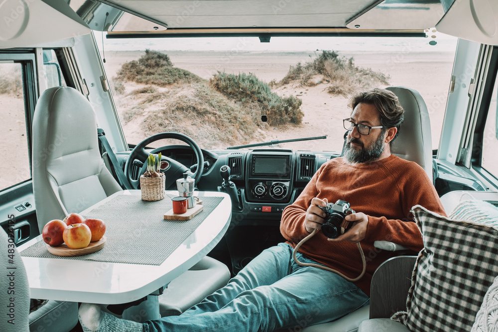One man sitting and relaxing inside a camper van motor home dinette ...