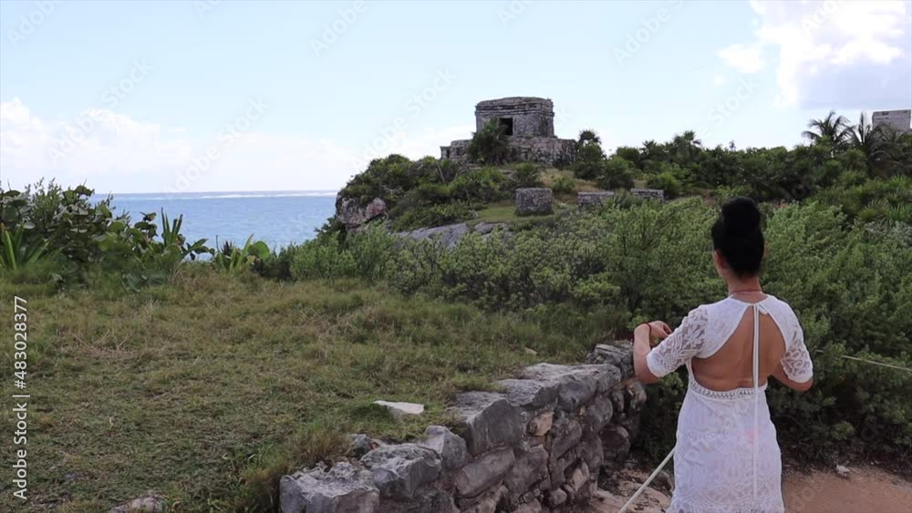 Young woman taking a picture of the Mayan ruin of Tulum in Yucatan ...