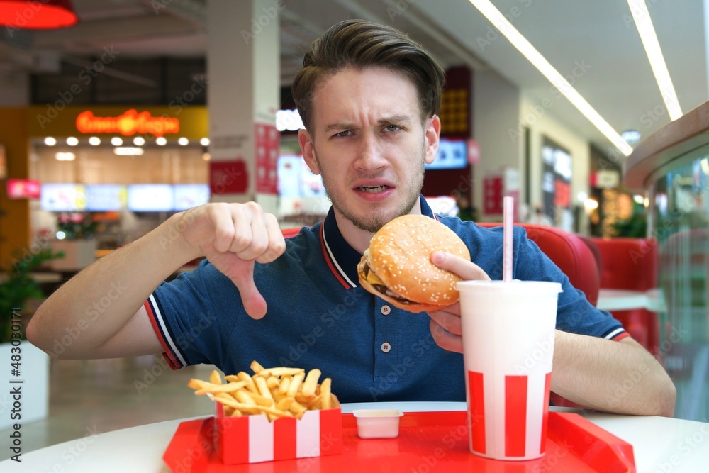 Young negative sad angry unpleased dissatisfied man guy is sitting on ...