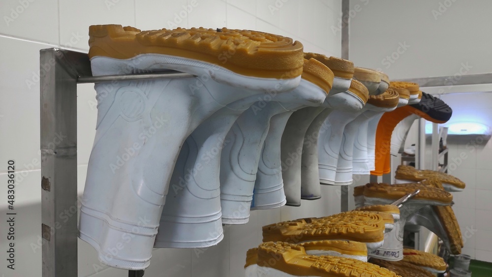Foto de Industrial background of boots on the rack for factory workers ...
