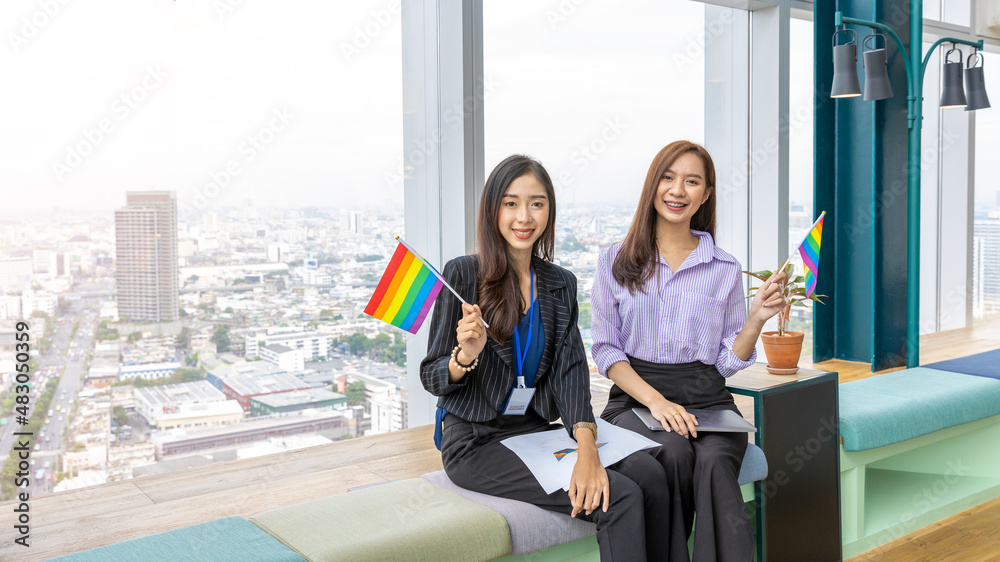 Two female office workers show rainbow flags to support human rights ...