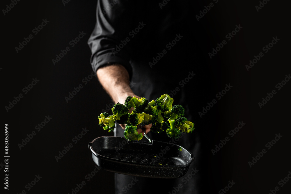 Professional Chef Cooks Flambe Style. Hands of cook frying vegetables ...