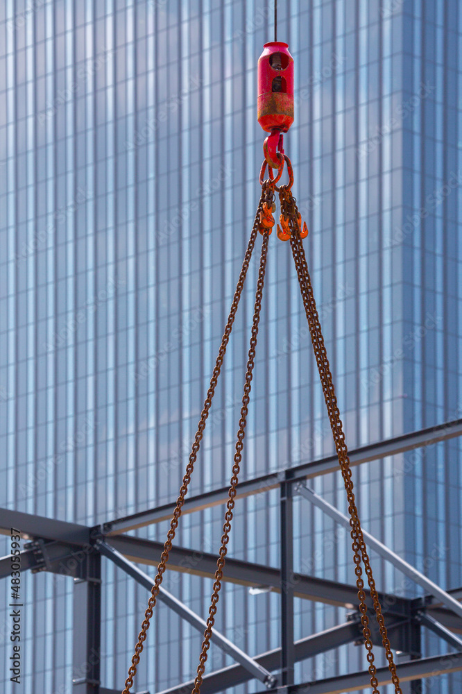 Crane hoisting block with hook on steel chain on steel rope. Glass ...