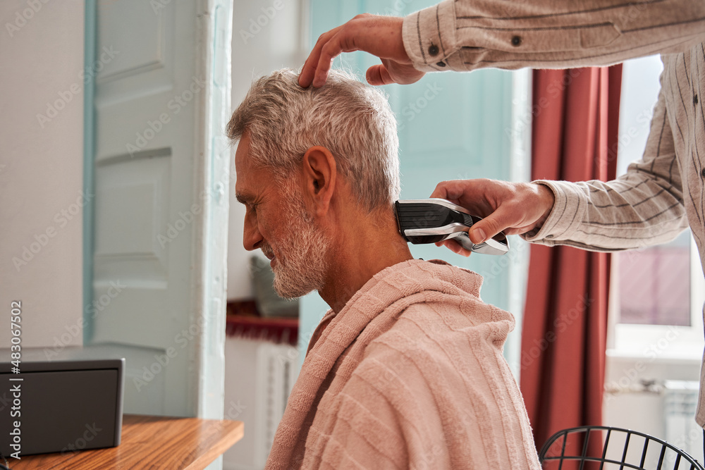 Son cutting his father's back of the head with special trimmer Stock ...