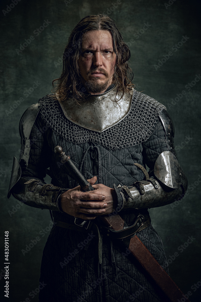 Half-length portrait of brutal seriuos man in image of medieval warrior ...