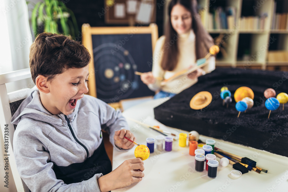 Happy school boy and girl making a solar system for a school science ...