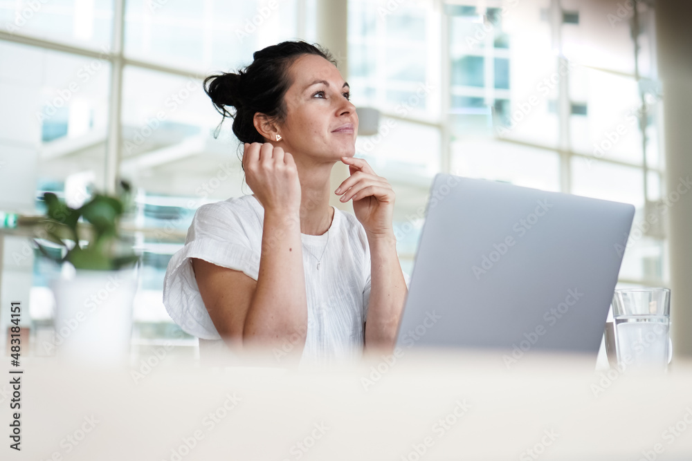 thoughtful brooding remote working dark haired woman sitting infront of ...