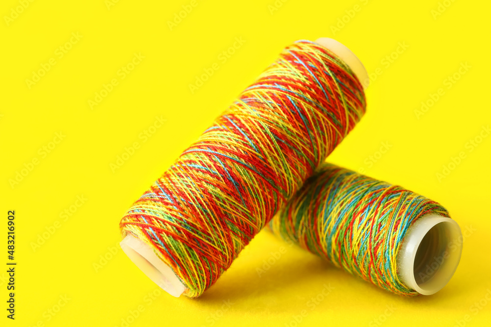 Rainbow sewing thread spools on color background Stock Photo | Adobe Stock