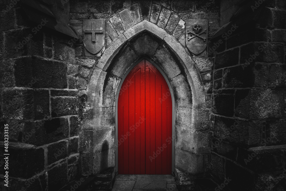 Scary pointy red wooden door in an old and wet stone wall building with ...