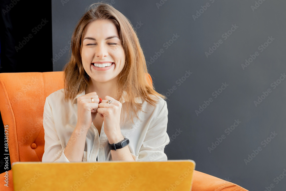 Joyful young business woman is happy about her work achievement ...