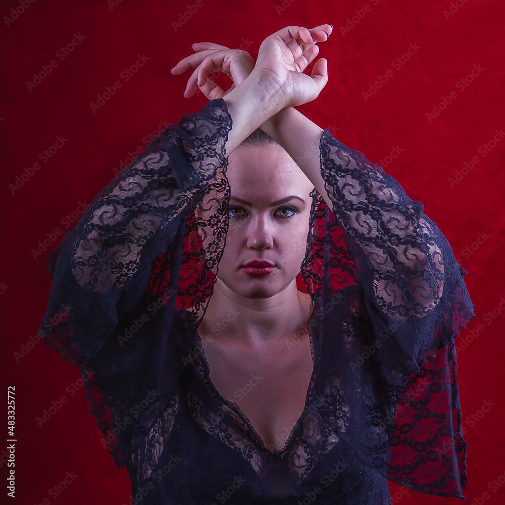 Portrait of an imperious lady in red and black tones, raising her hands ...