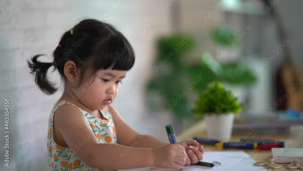 Asian baby girl drawing with colourful crayon , happy funny child girl ...