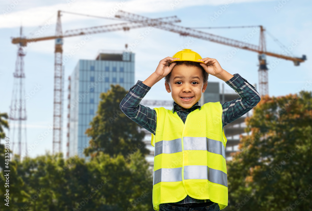 building and profession concept - smiling little boy in yellow safety ...