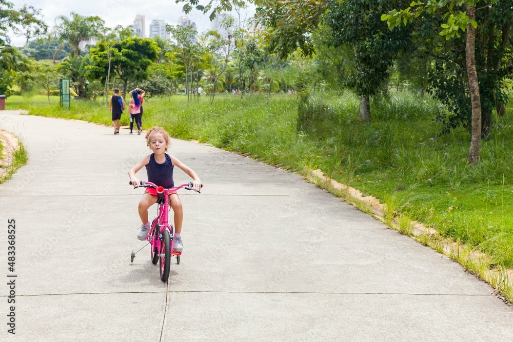 Girl riding a bicycle in urban park in the summer of Brazil. Urban Park ...