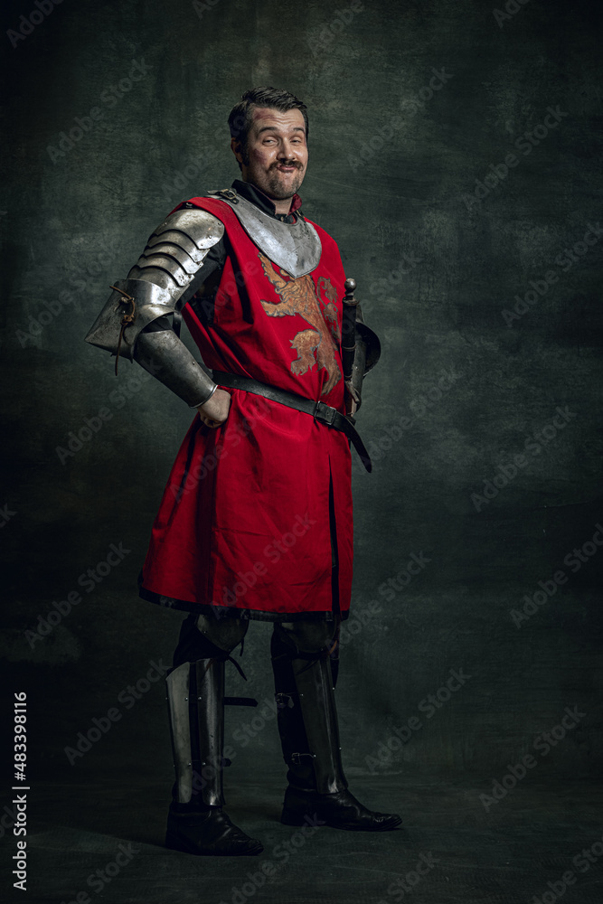 Portrait of smiling man in image of medieval warrior with dirty wounded ...