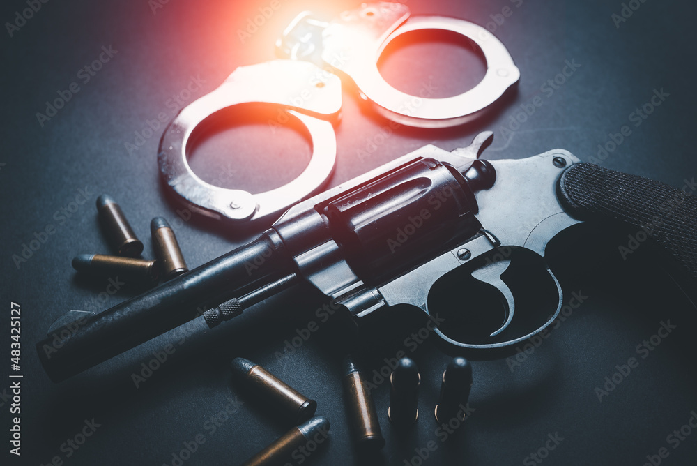 Guns, ammunition and shackle placed in a dark table,Short guns ...