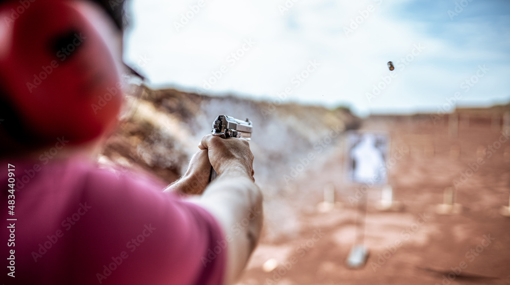 Detail view of shooter holding gun and training tactical shooting ...