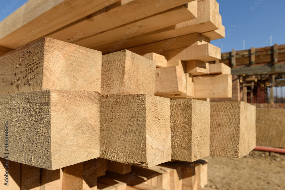Wooden building materials. Stacked boards at a construction site ...