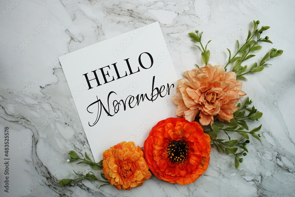 Hello November text with orange flower bouquet on marble background ...