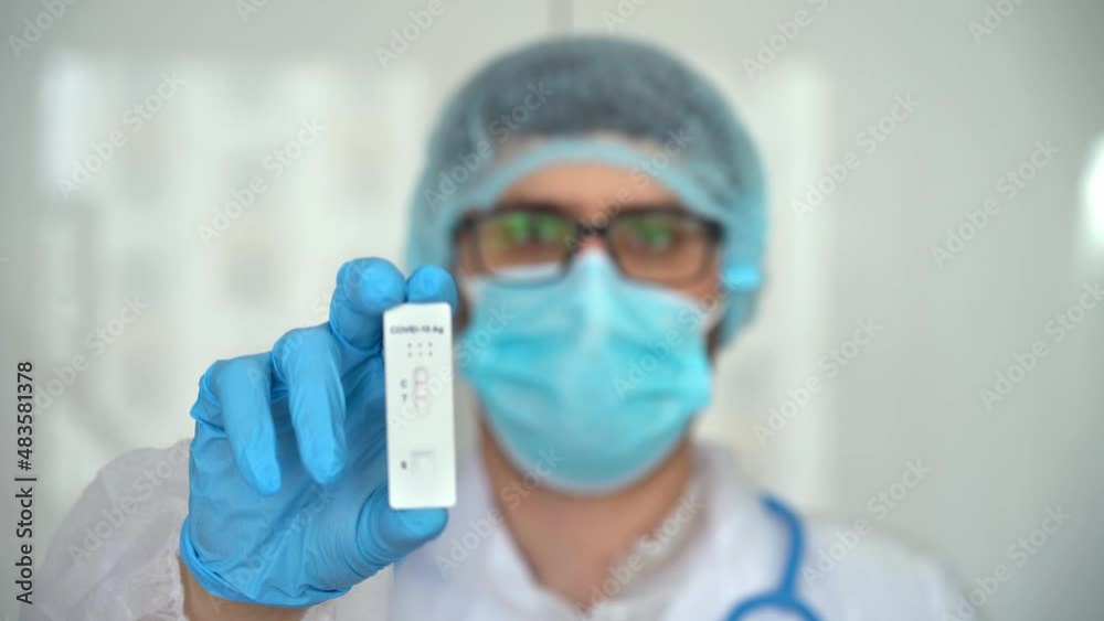 Male doctor in protective mask holds rapid antigen test for covid-19 in ...