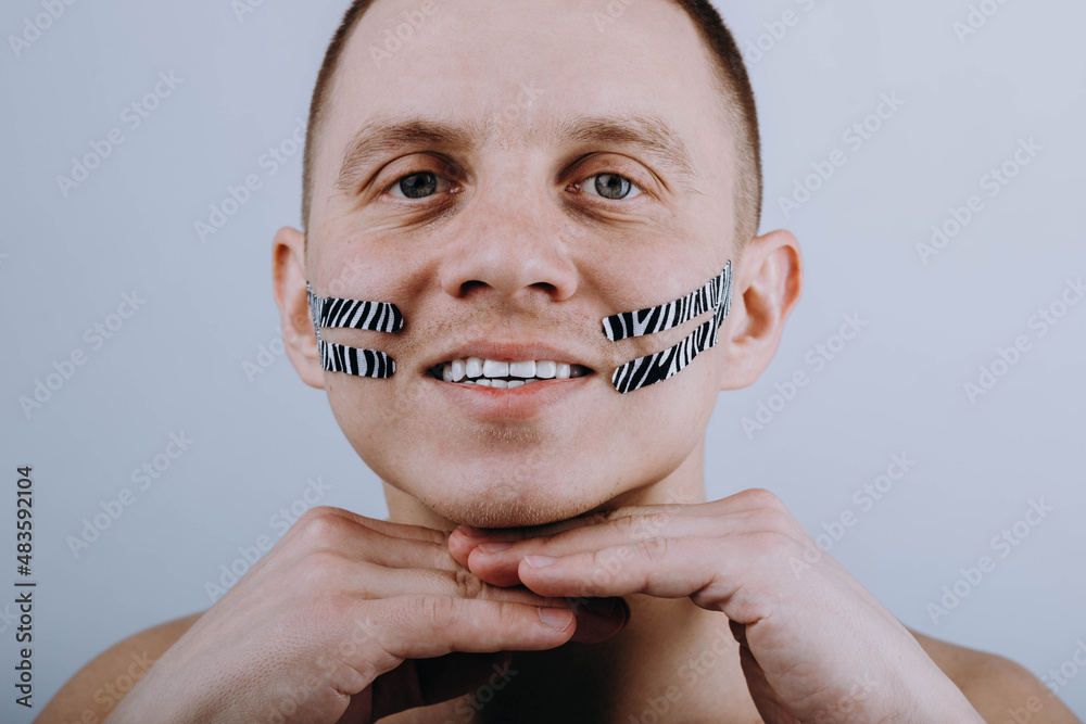 Close-up of a guy's face with an anti-wrinkle cosmetic tape. Aesthetic ...