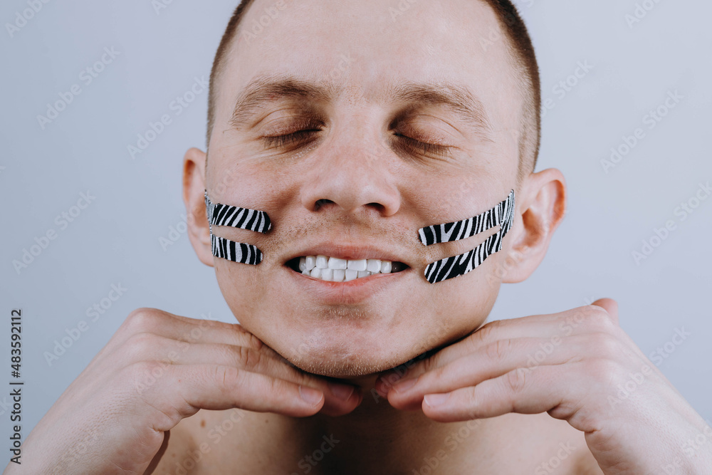 Close-up of a guy's face with an anti-wrinkle cosmetic tape. Aesthetic ...