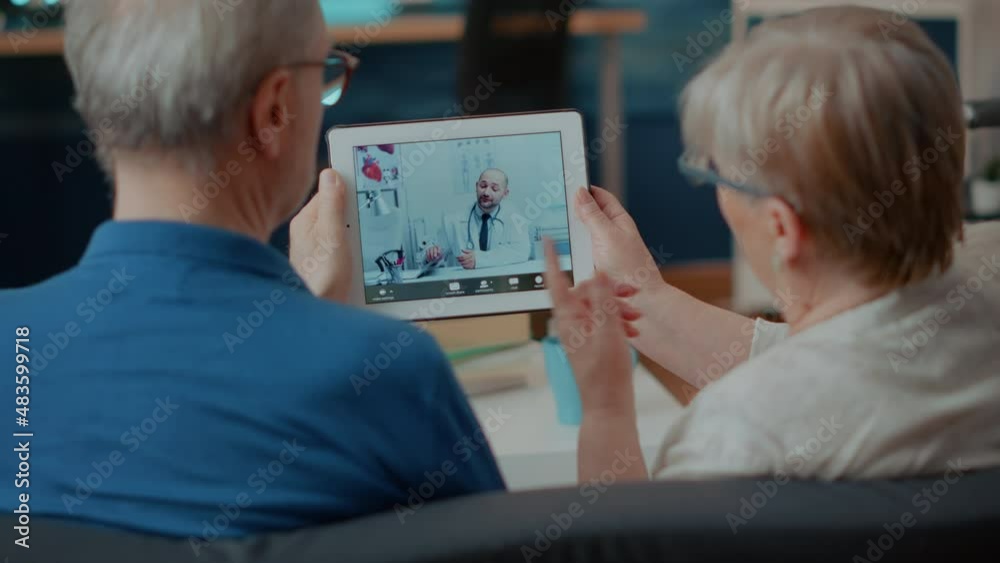 Senior couple attending online meeting with doctor on digital tablet ...