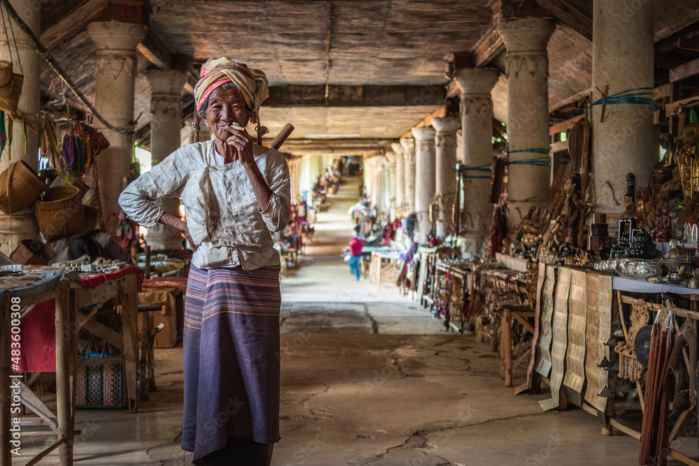 Old Burmese lady smoking a cigar at traditional market in Indein ...