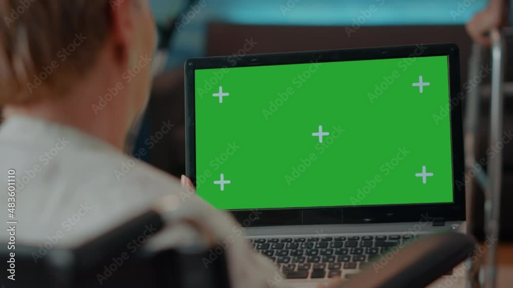 Elder person with disability using green screen on laptop, looking at ...
