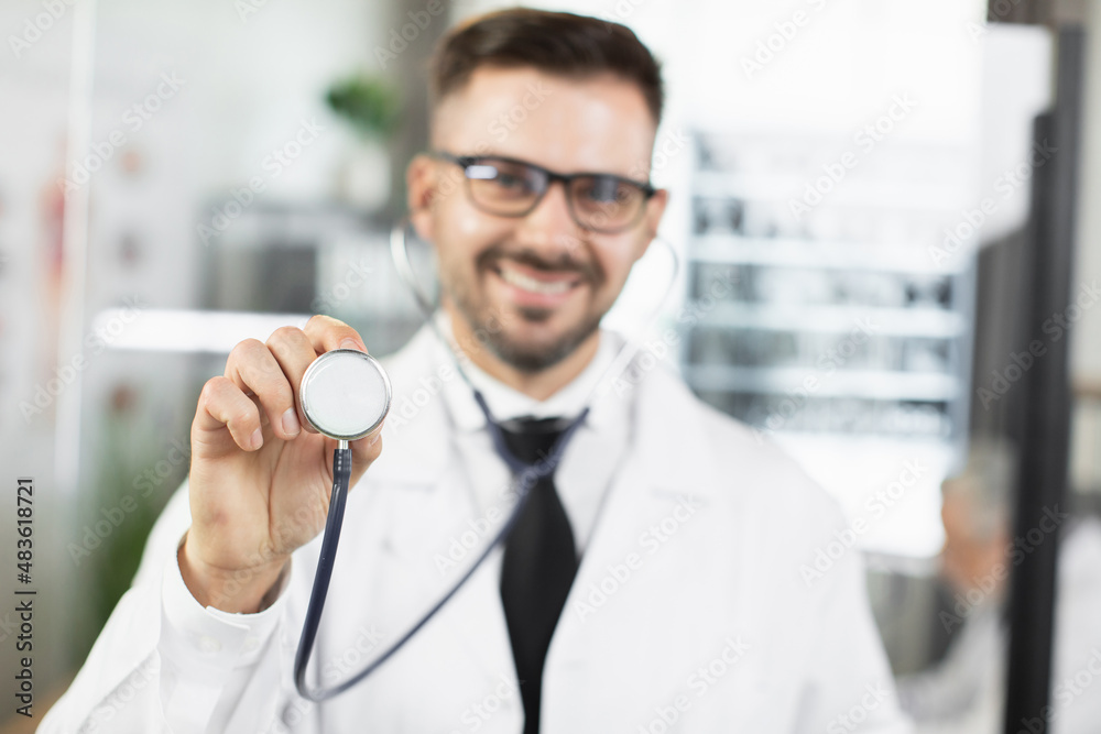 Caucasian medical worker in lab coat and eyeglasses holding stethoscope ...