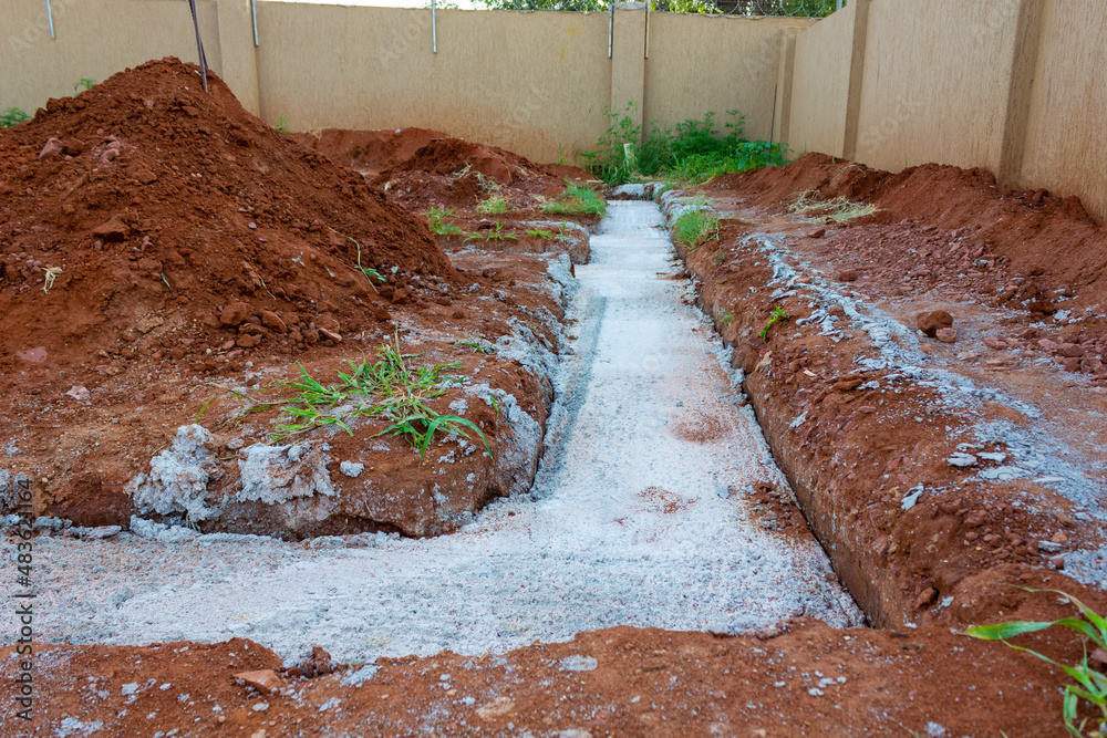 concrete foundation of a building. heaps of soil that was dug up next ...