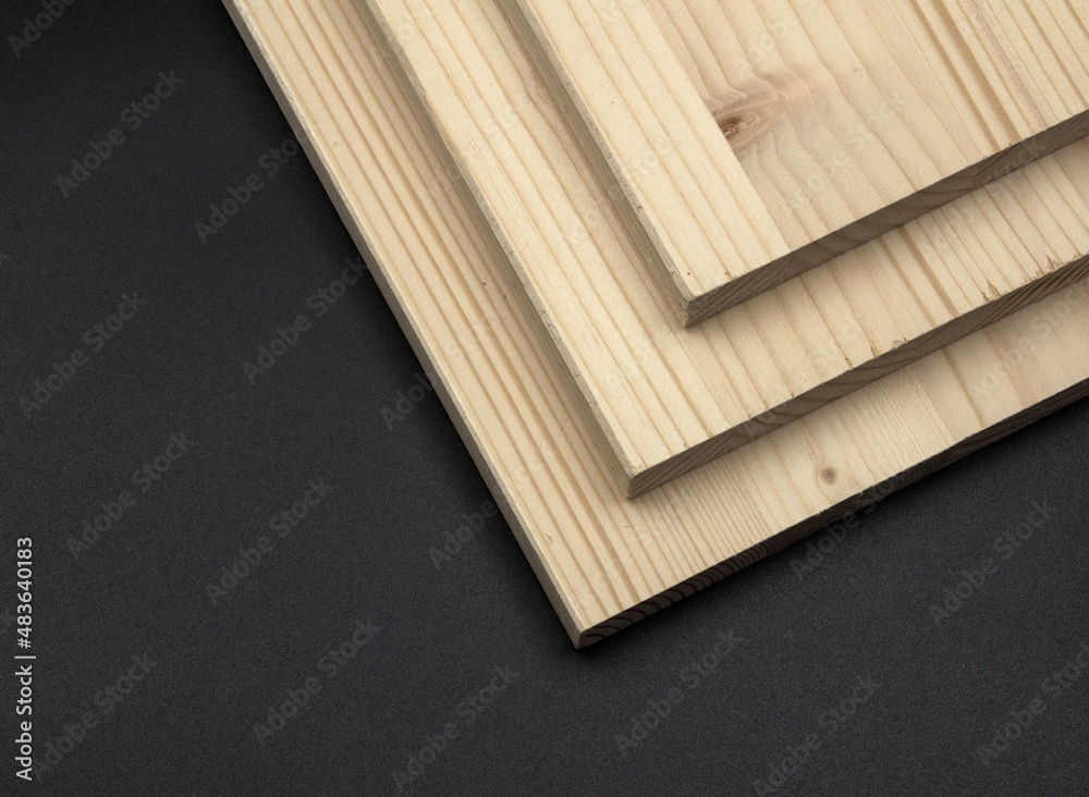 Three white pine boards in the shape of a triangle, on a black ...