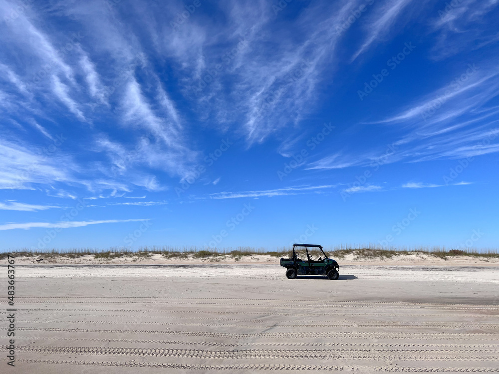 An ATV sits on the sand of a beach on the Outer Banks of North Carolina ...