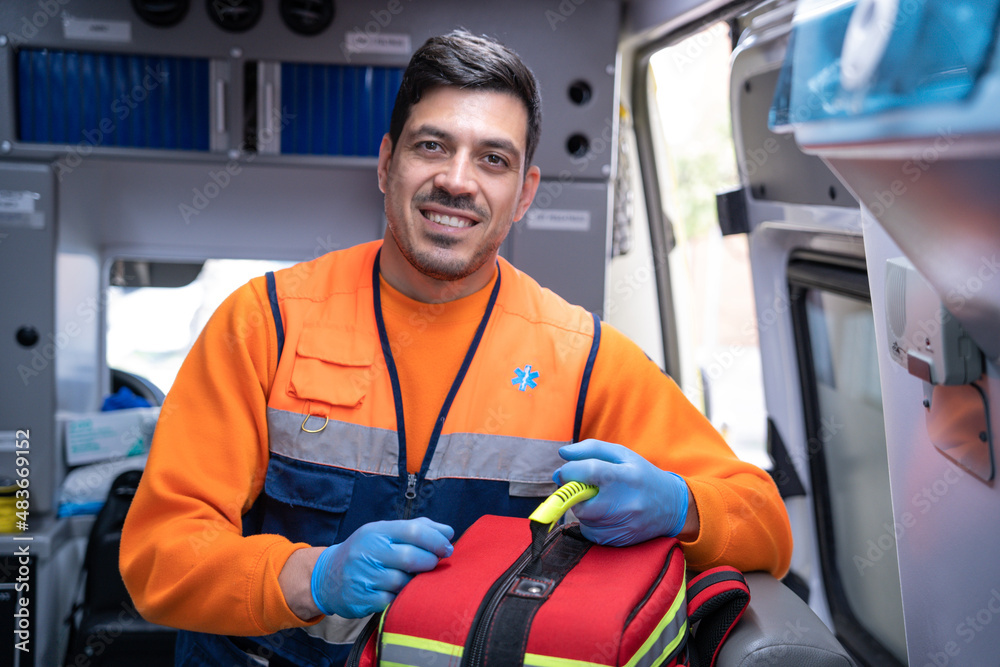 Foto de handsome young paramedic smiling inside an ambulance with a ...