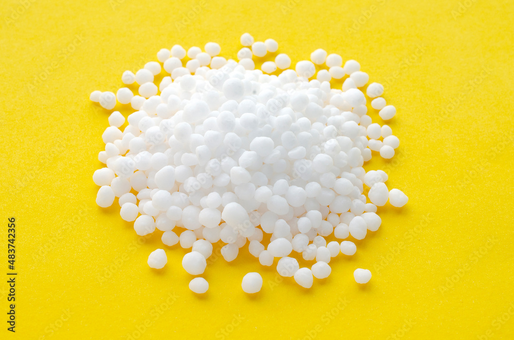 Urea granules on a yellow background, space for text, top view ...