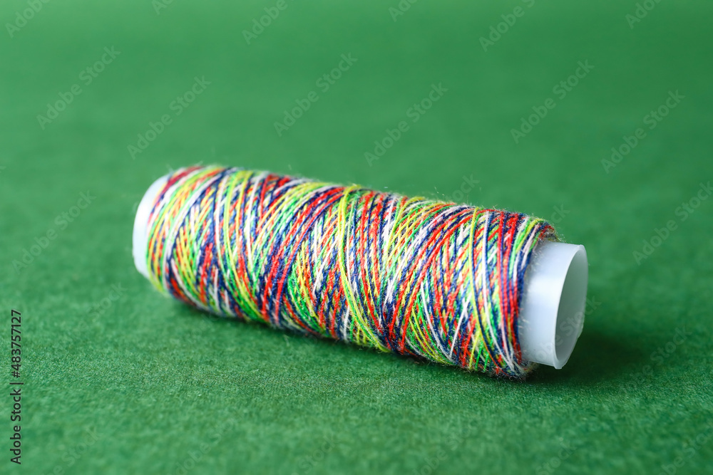 Rainbow sewing thread spool on color background Stock Photo | Adobe Stock